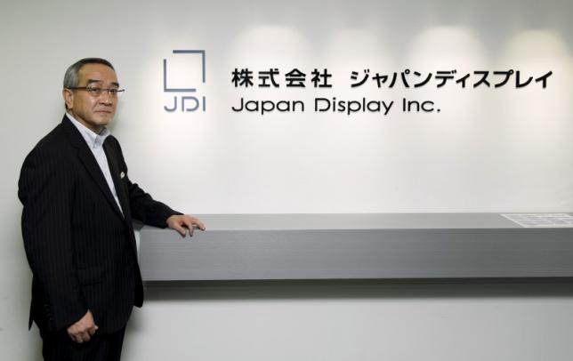 Homma poses in front of the company's logo at its headquarters in Tokyo ...